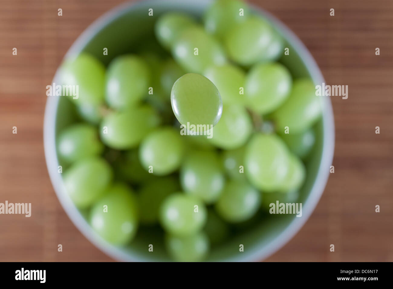 One Green Grape Falling Down to a Grape Bowl Stock Photo - Alamy