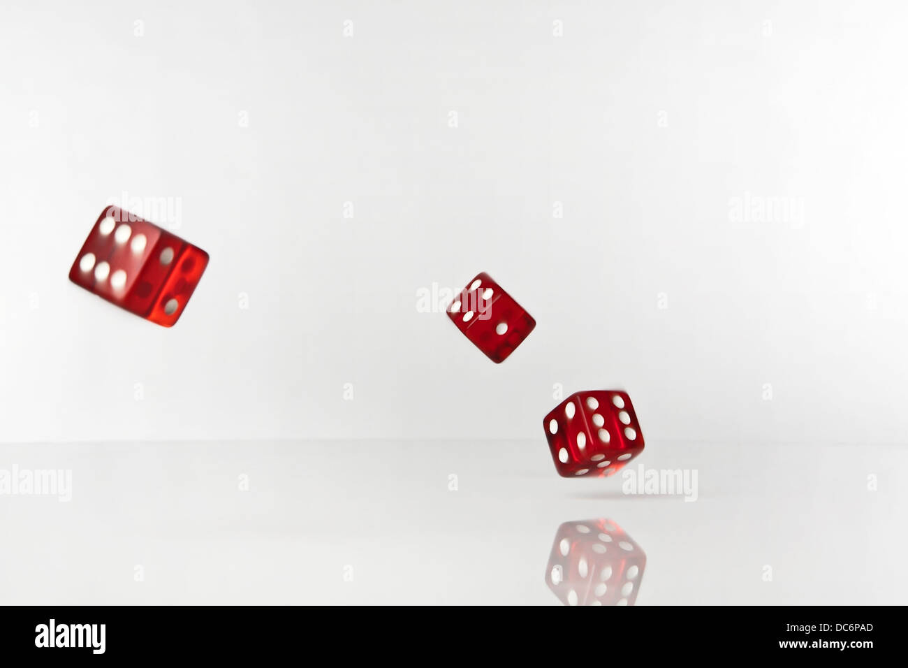 Dice rolling on plain white background Stock Photo - Alamy