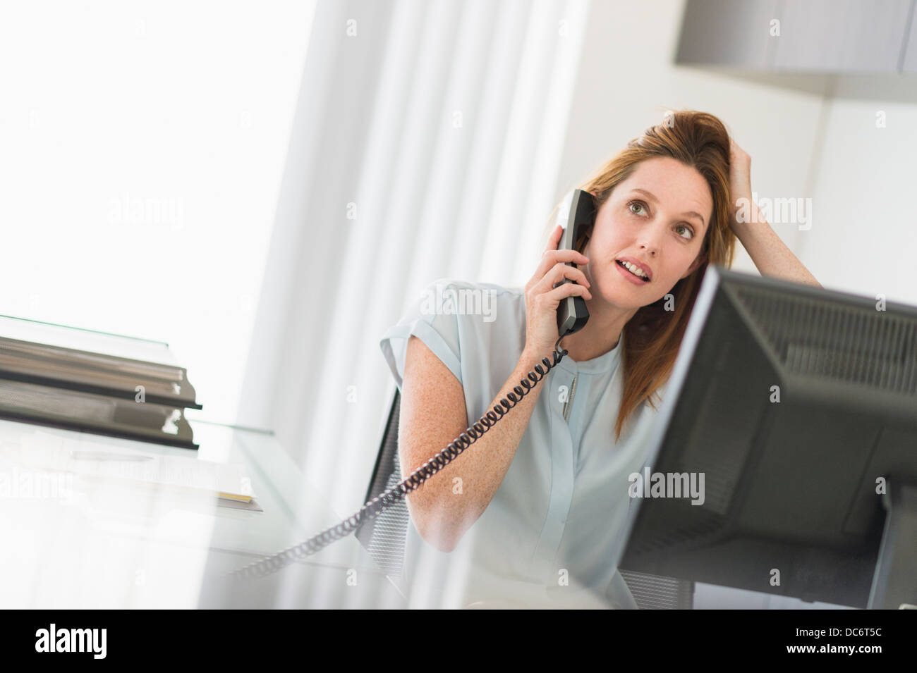 Business woman using computer and phone in office Stock Photo - Alamy