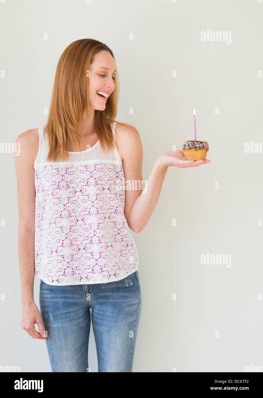 Woman holding birthday cupcake Stock Photo - Alamy
