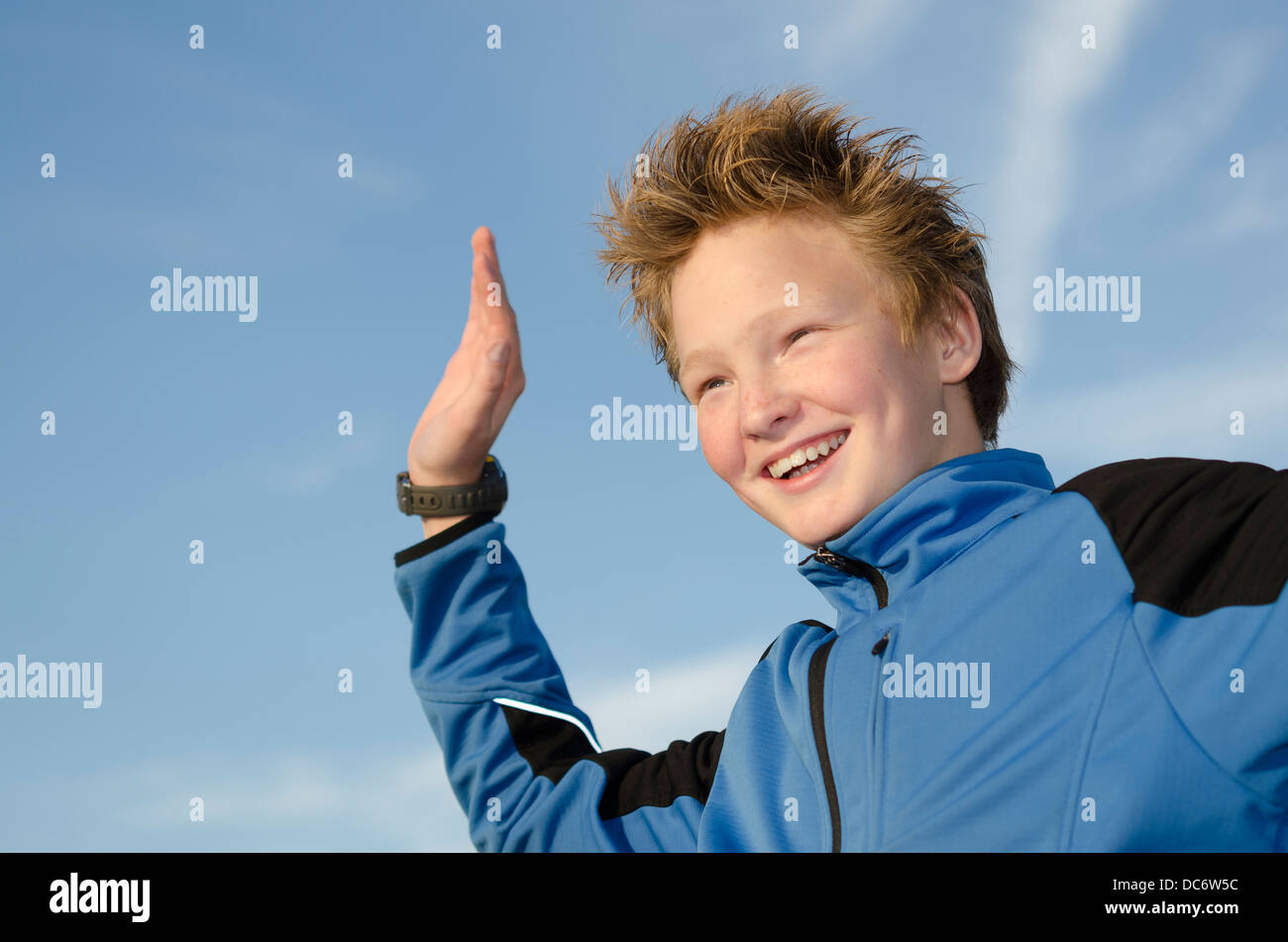 Happy kid with spiky hairstyle joyfully welcome against blue sky Stock ...