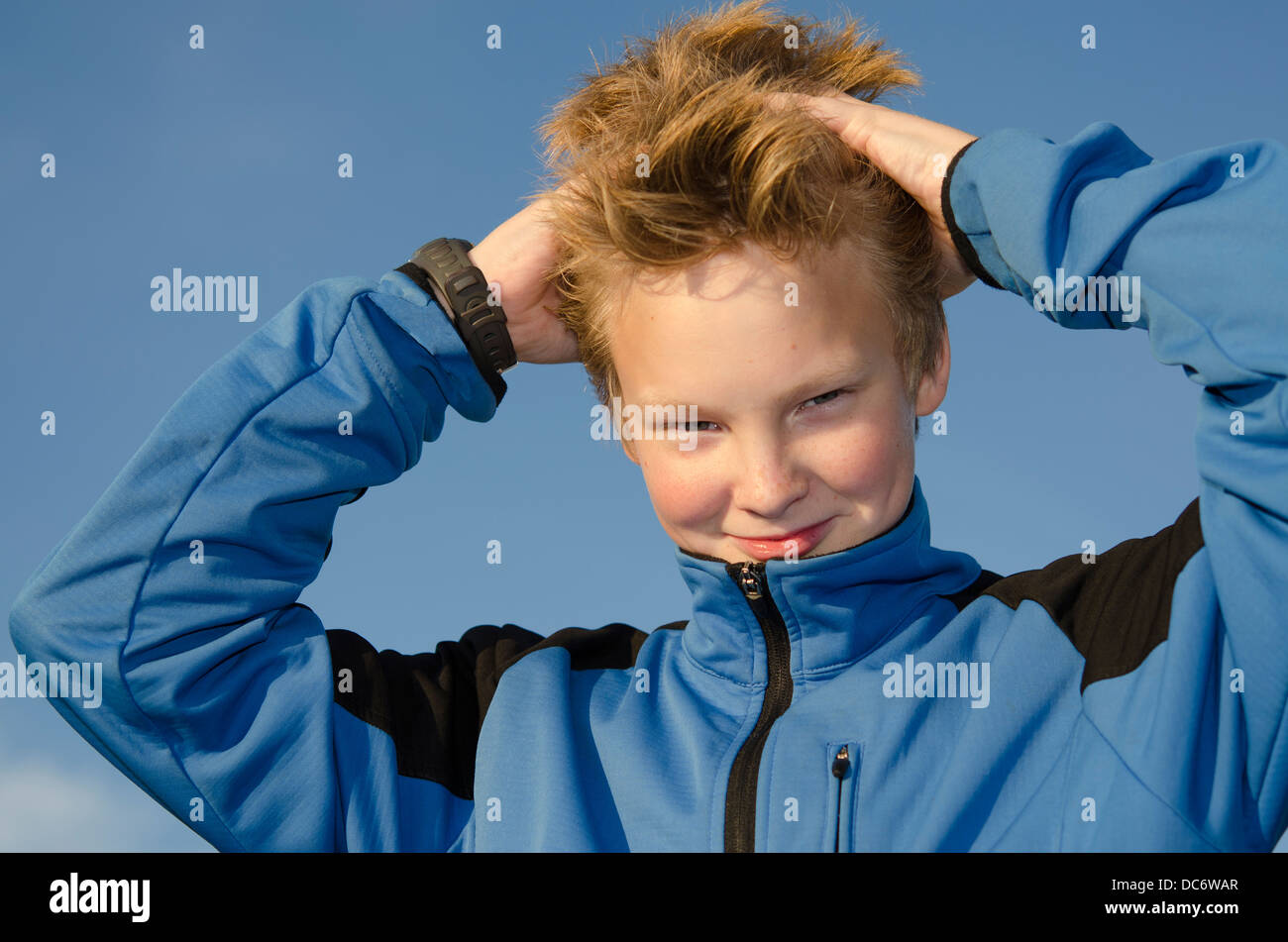 Kid adjusts his spiky hairstyle against blue sky background Stock Photo ...