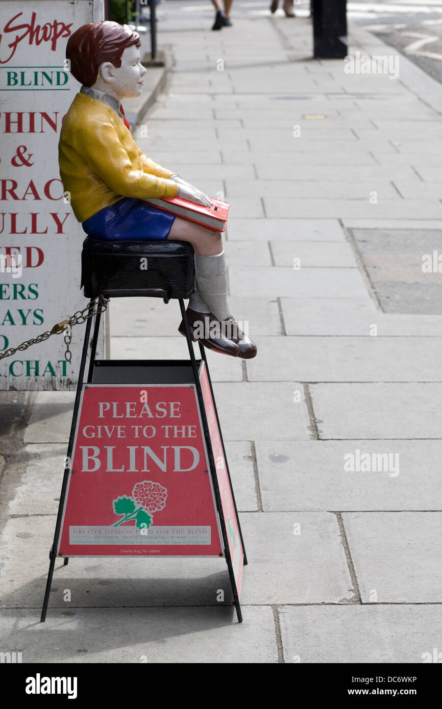 Collection Box with a statue of a blind boy sat on top "Please give to ...