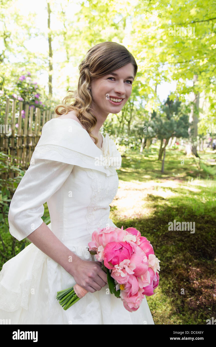Netherlands. Hague, Portrait of bride with bouquet of pink flowers ...