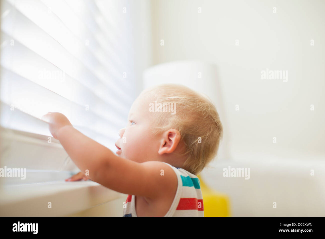 Baby boy (6-11 months) looking through window Stock Photo - Alamy