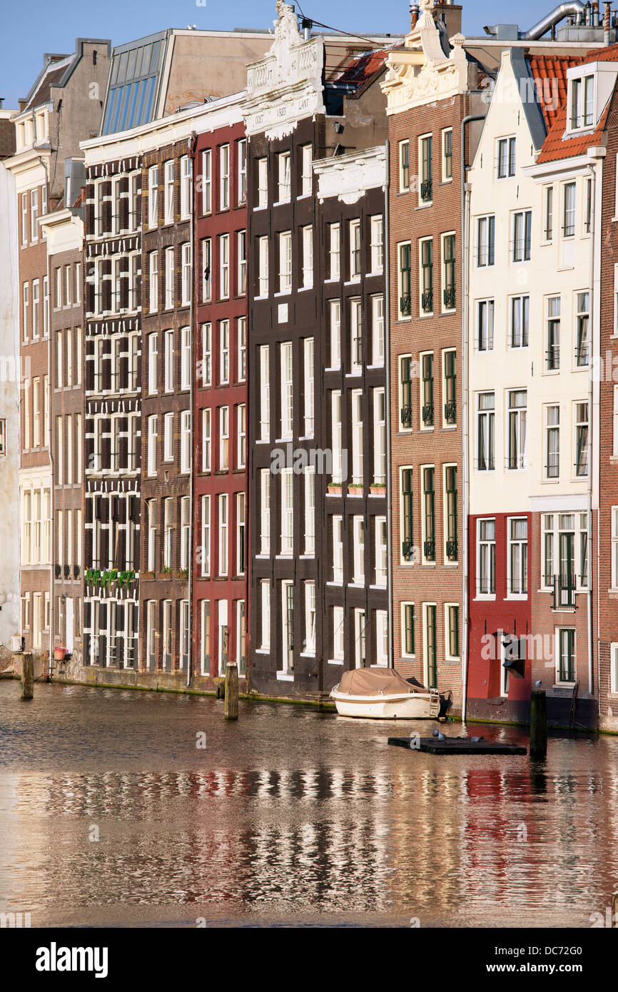Old row houses by the canal in the city of Amsterdam, Holland ...