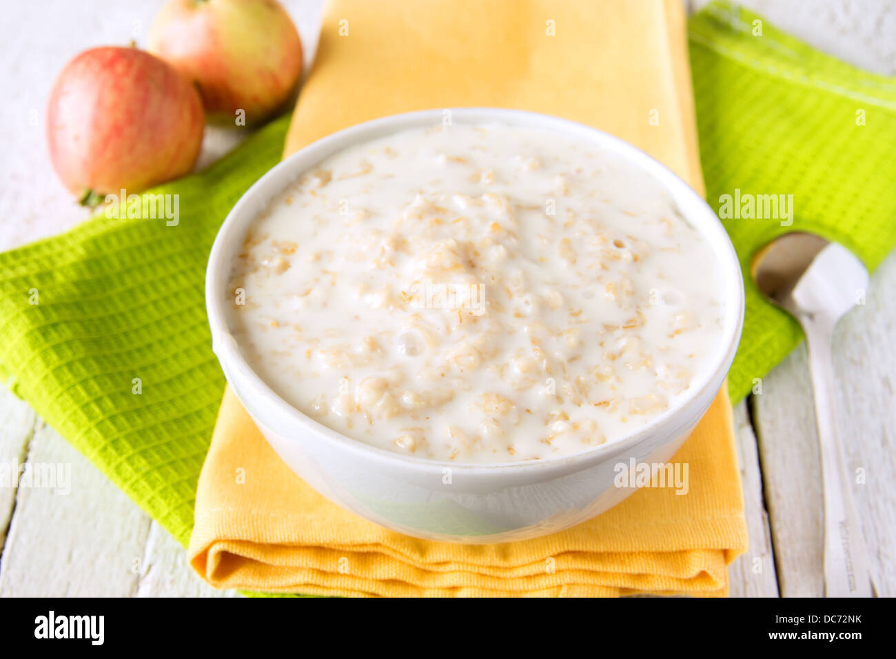 Oatmeal fresh hot simple porridge with spoon on napkin and wooden table ...