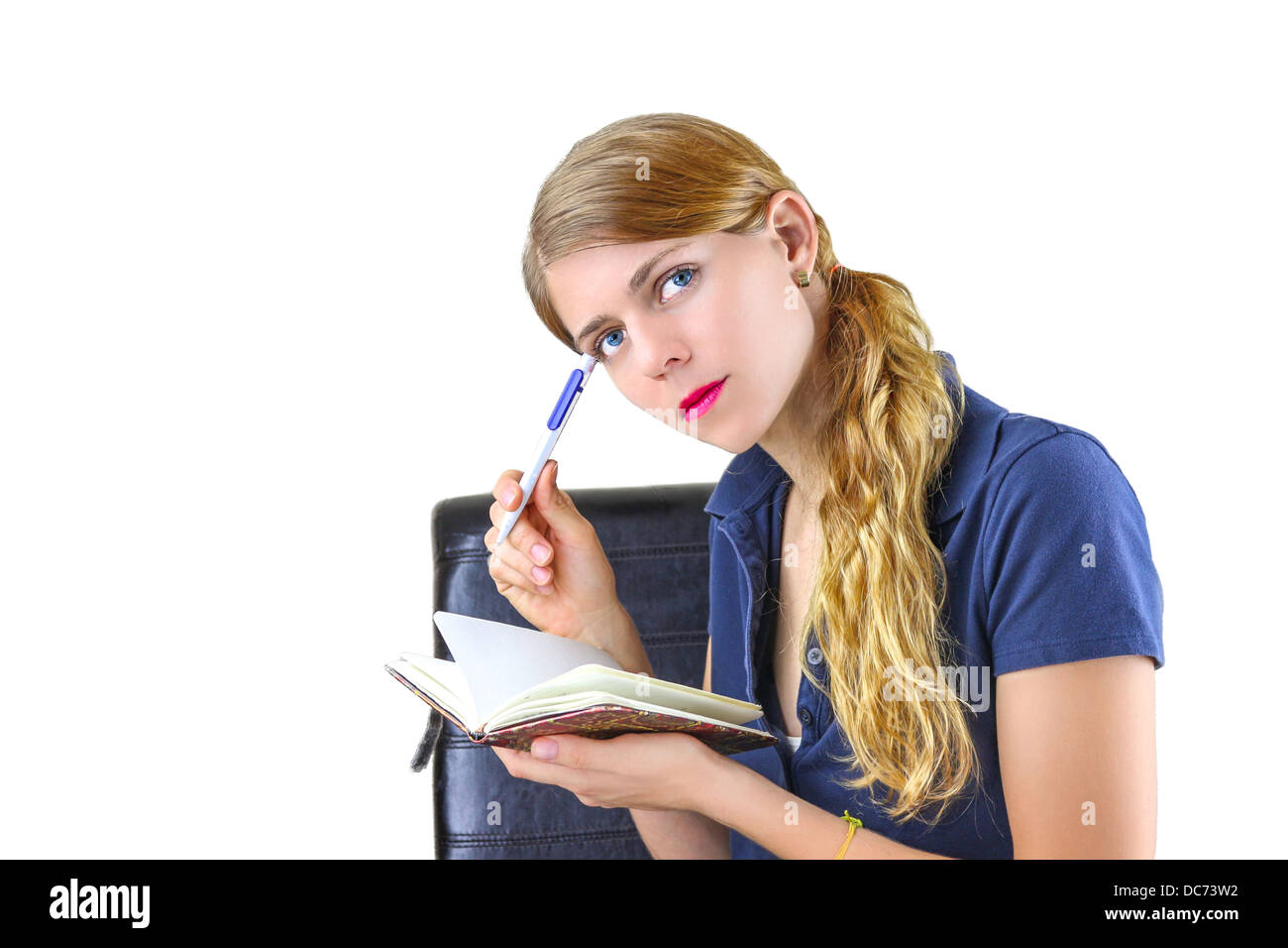 Lovely young woman thinking while writing on notepad Stock Photo - Alamy