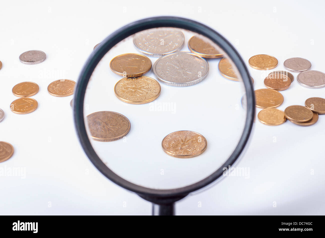 an image of coins lying on magnifying glass Stock Photo - Alamy