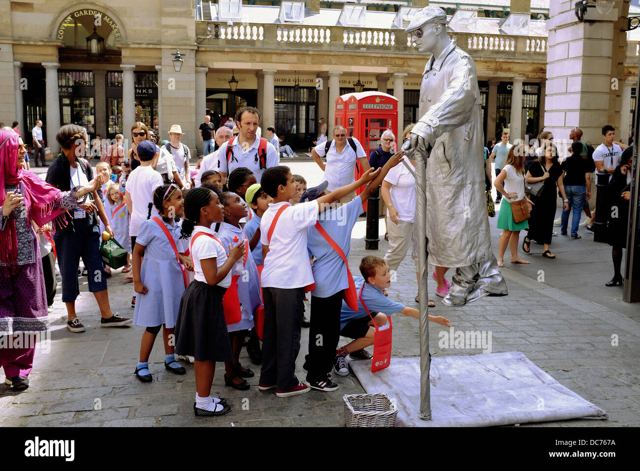 Children investigate a "floating" human statue in Covent Garden, London ...