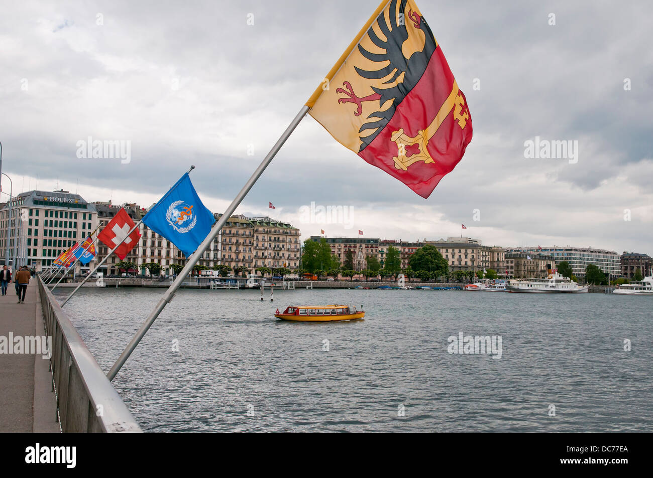 Flags of Geneva ,the province and the country on the bridge over lake ...