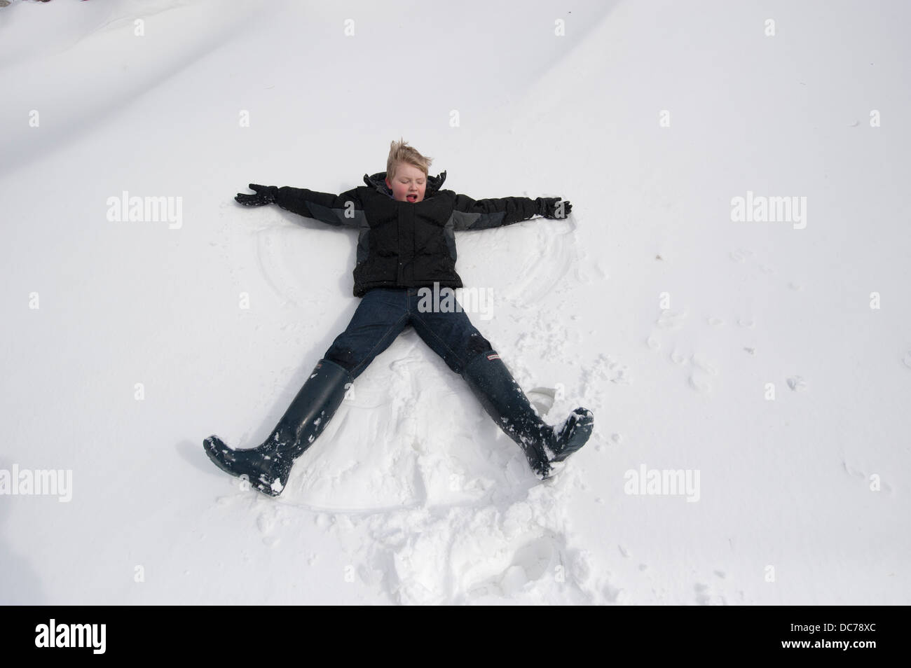 Boy making snow angels in snowdrift, Cumbria, UK Stock Photo - Alamy