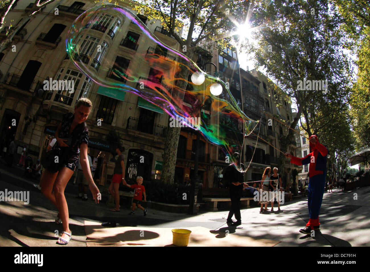 Men dressed as superheroes make giant soap bubblesto attract tourists ...