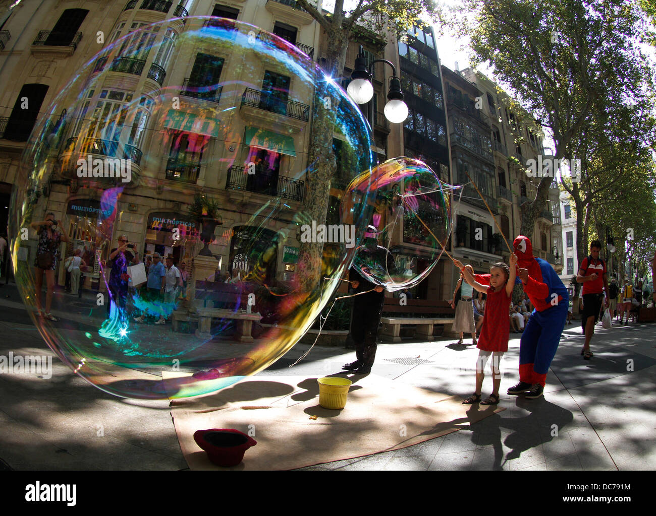 Men dressed as superheroes make giant soap bubblesto attract tourists ...