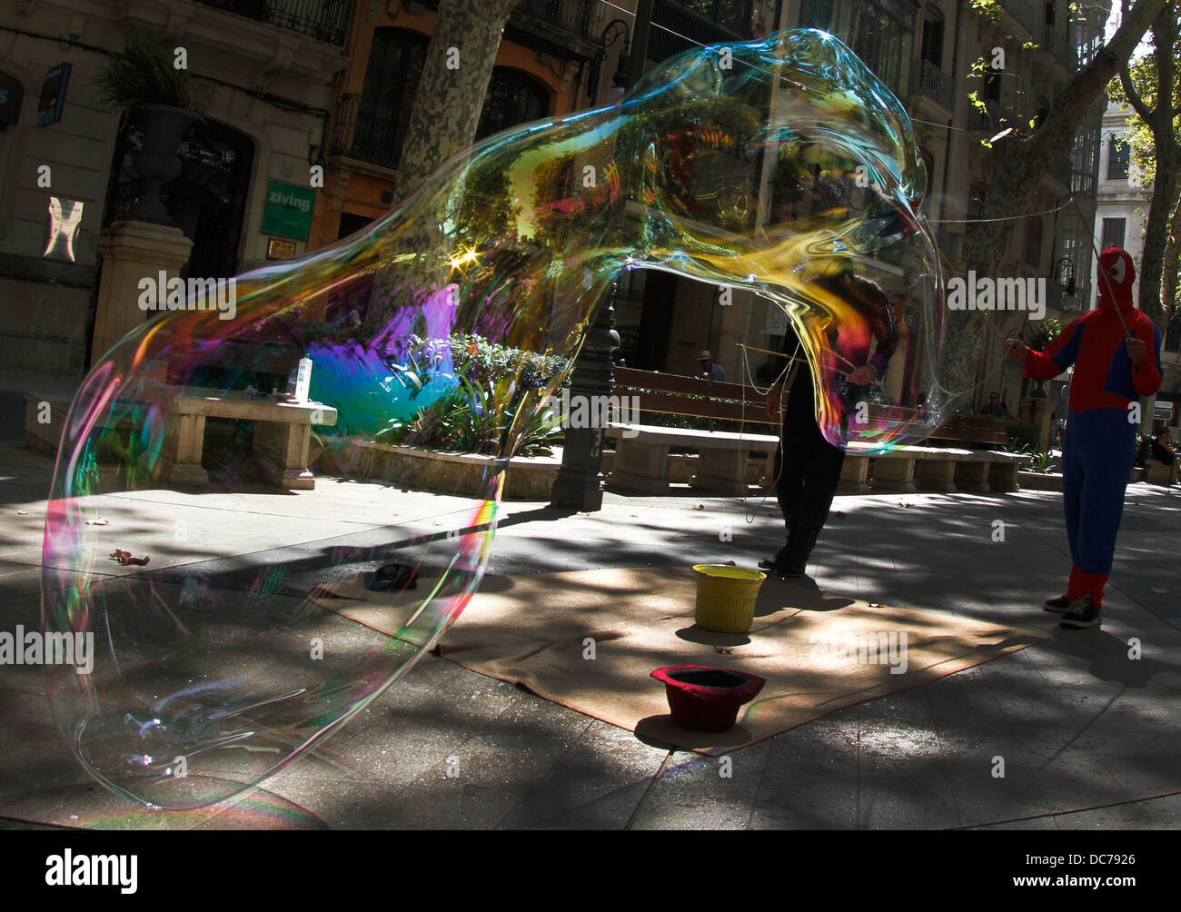 Men dressed as superheroes make giant soap bubblesto attract tourists ...