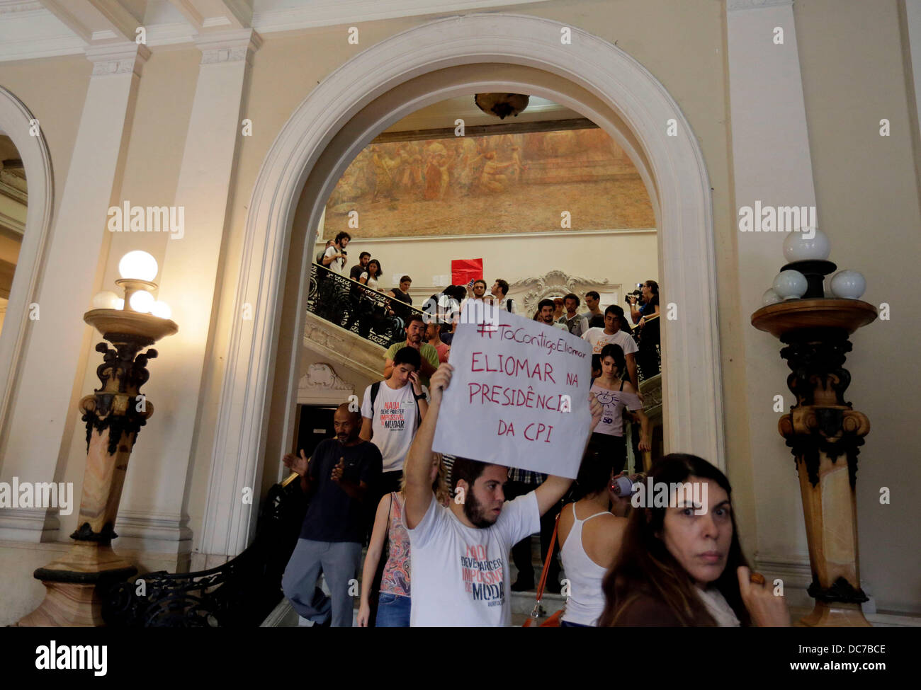 Demonstrators carry posters and hang protest on the floor of Camara ...
