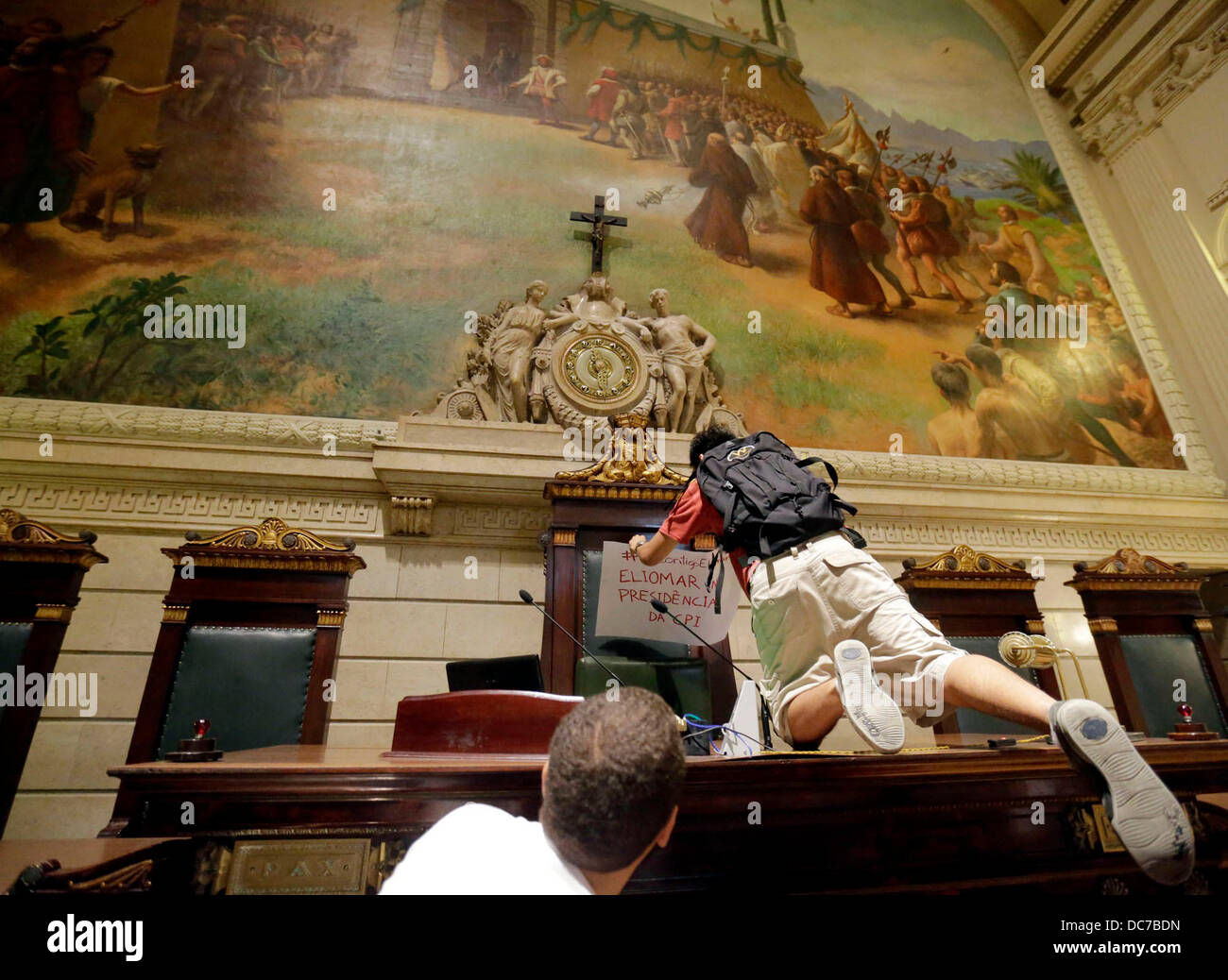 Demonstrators carry posters and hang protest on the floor of Camara ...