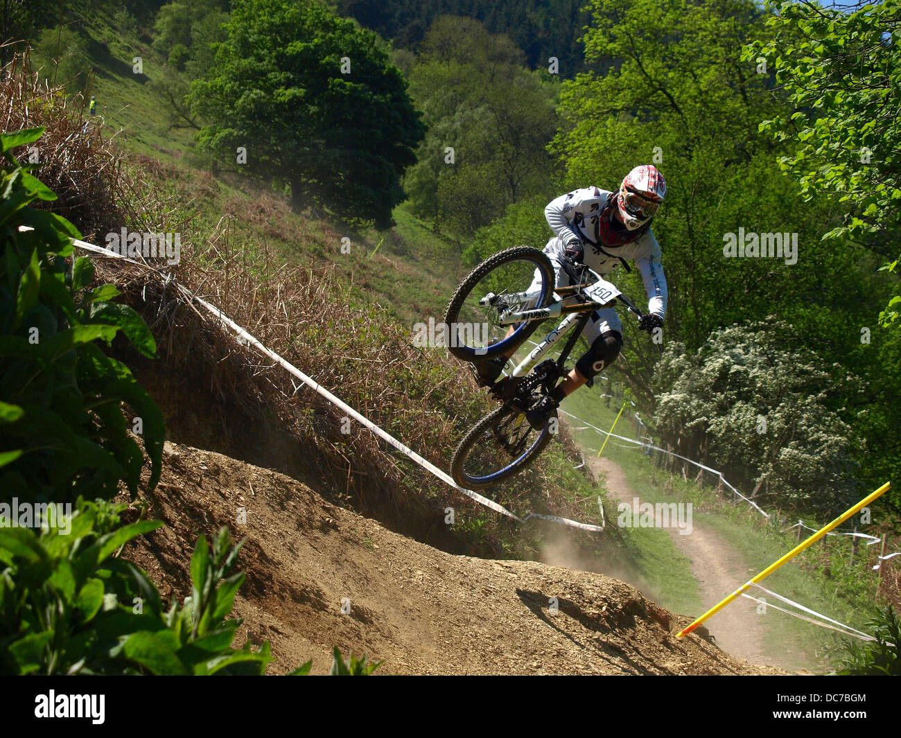 Mountain biker jumping on dusty track Stock Photo - Alamy