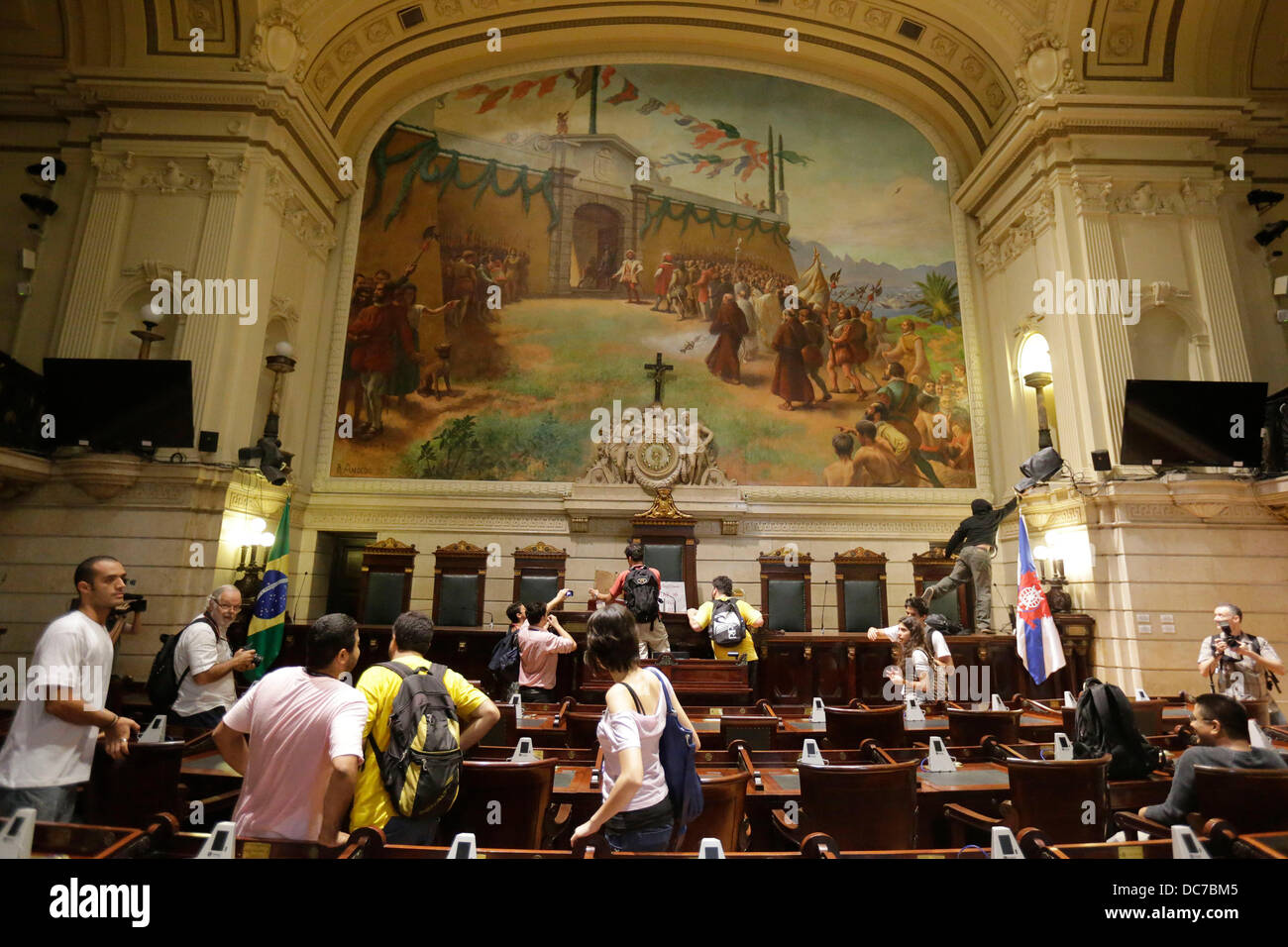 Demonstrators carry posters and hang protest on the floor of Camara ...