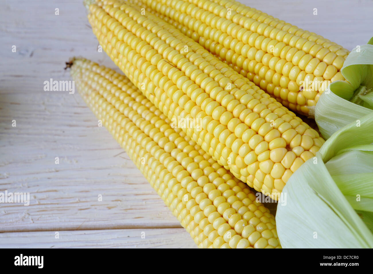 Three fresh corn cobs on the table, food Stock Photo - Alamy