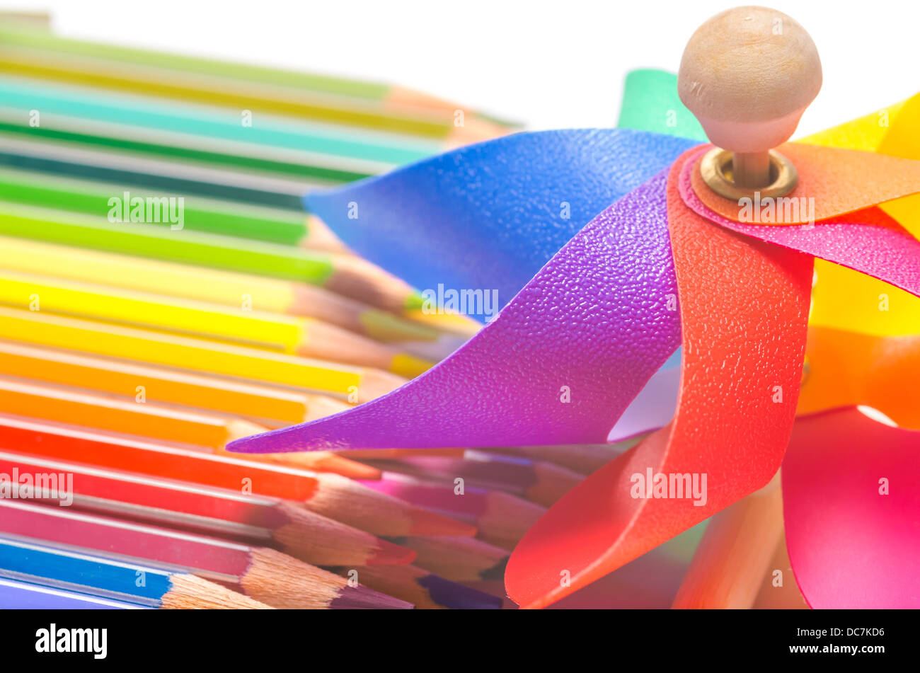 Colourful toy pinwheel with a collection of coloured pencils in the ...