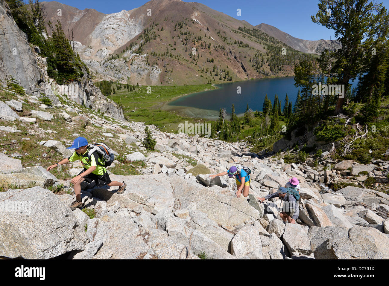 Family hiking up a steep talus slope in Oregon's Wallowa Mountains ...