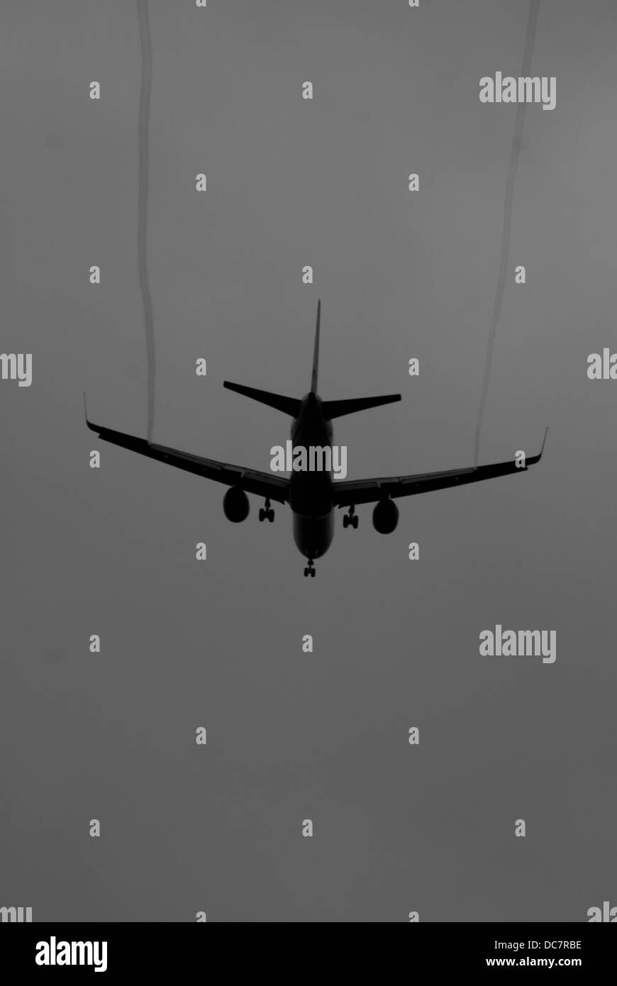 Aircraft on final approach showing wake trails Stock Photo - Alamy