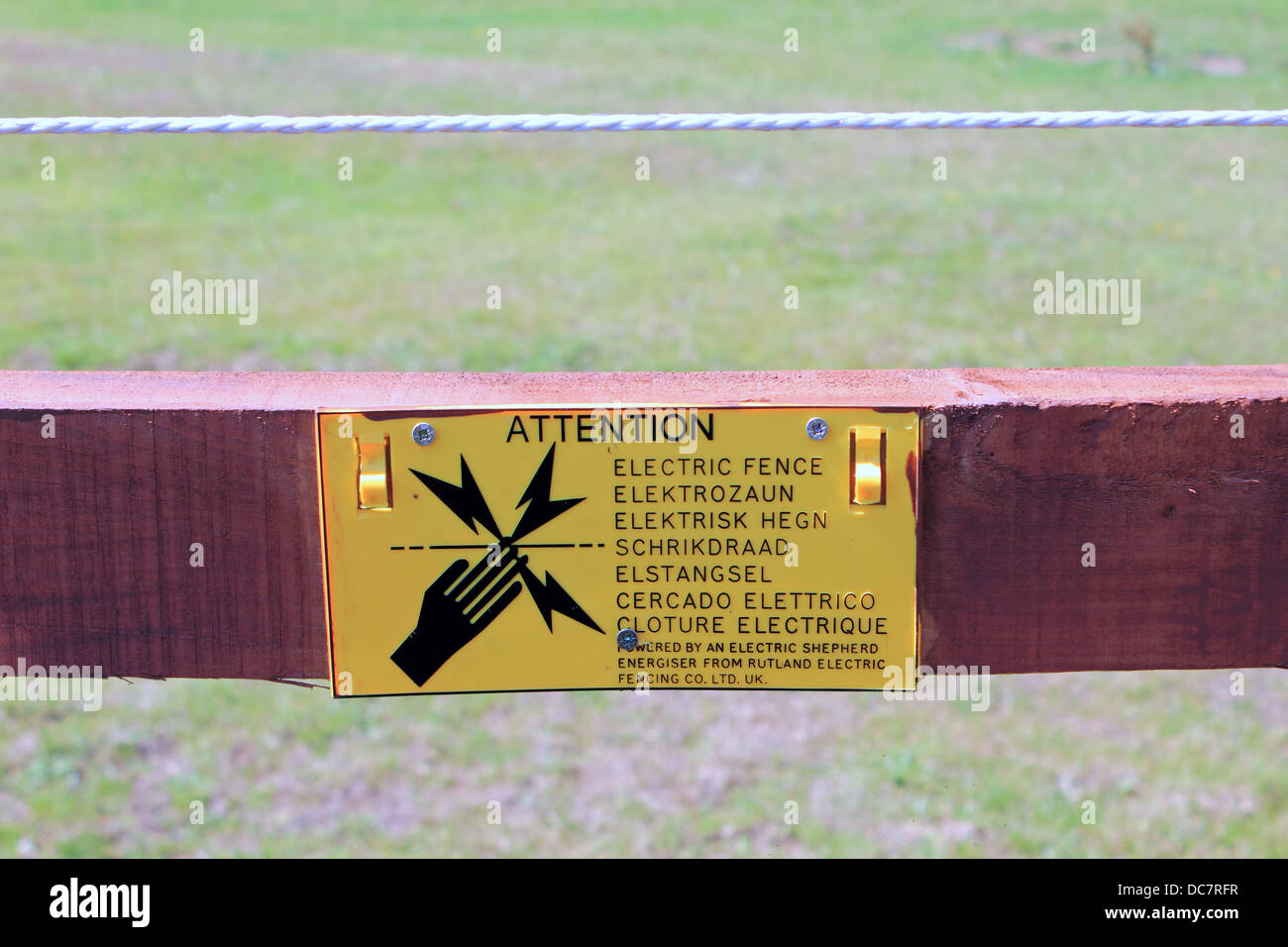 Attention electric fence sign in many languages. UK Stock Photo - Alamy