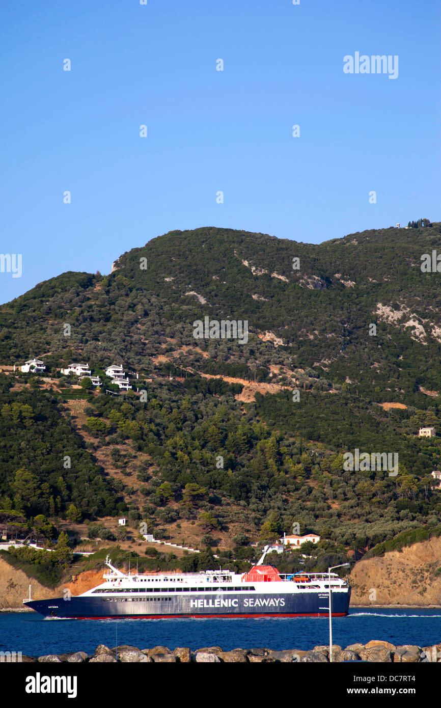 Greek ferry leaving Sopelos harbour with the hills of Skopelos in the ...