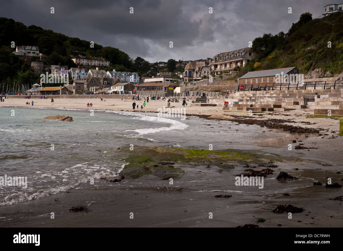 looe beach in the summer with a storm coming over Stock Photo - Alamy