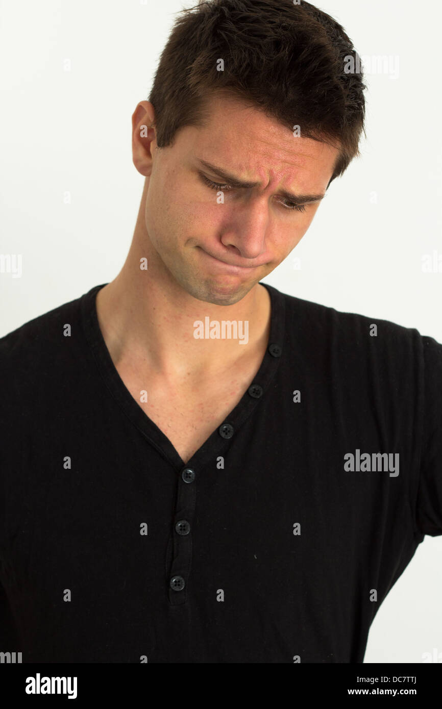 Sad man looking down in pain fully stressed Stock Photo - Alamy