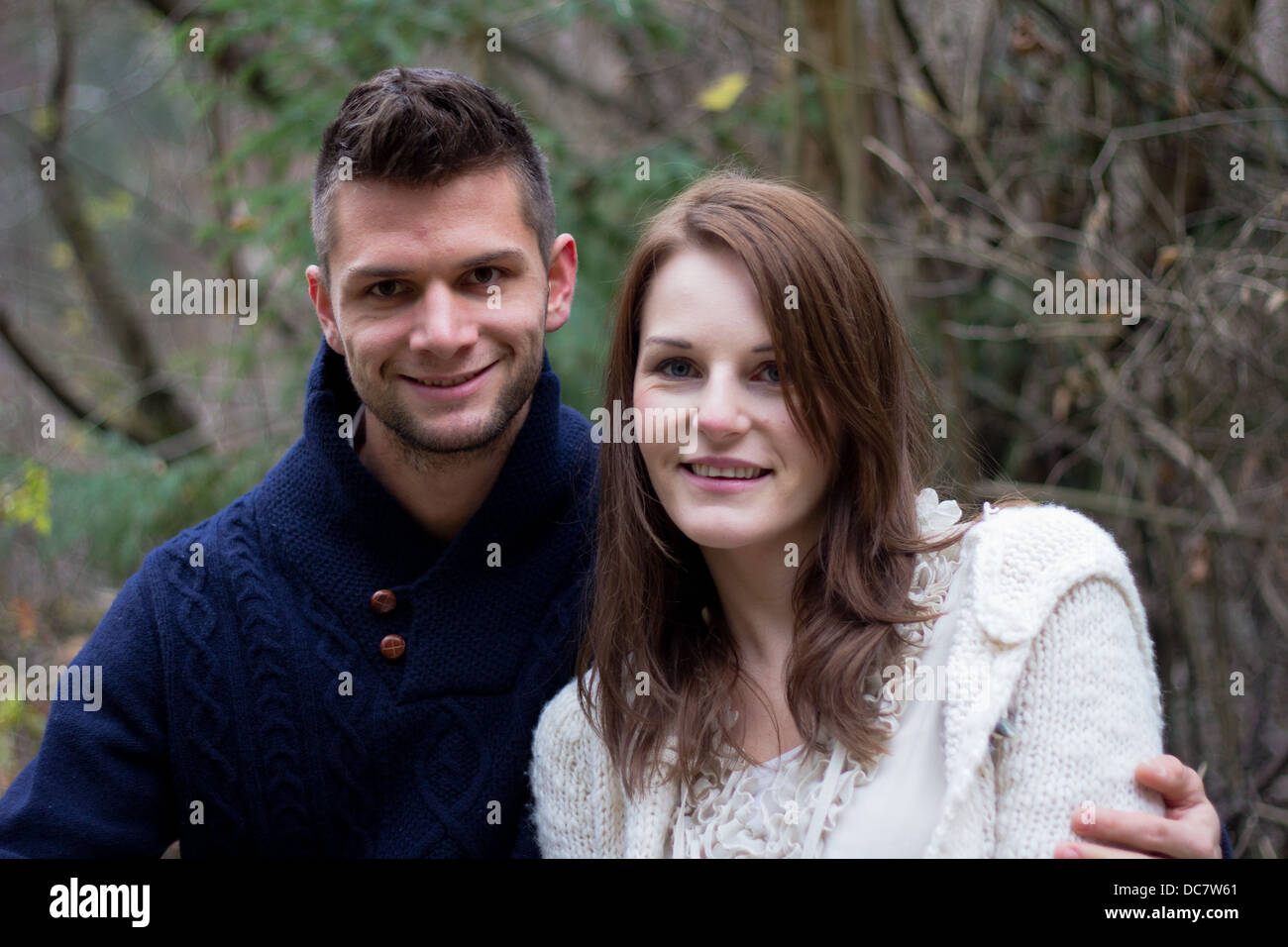 Cute couple smiling while being in the forest Stock Photo - Alamy