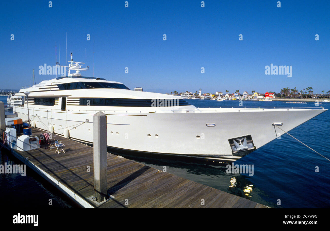 A sleek ocean-going yacht is tied up to a boat dock for provisioning in ...