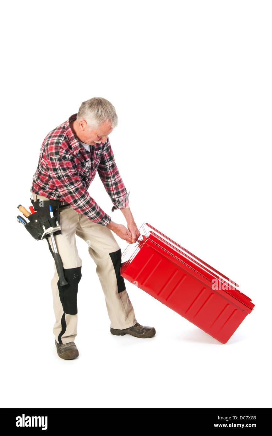 Senior man as manual worker pulling at heavy red tool kit Stock Photo ...