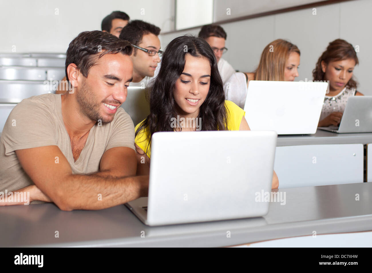 Students studying with laptops in class room Stock Photo - Alamy
