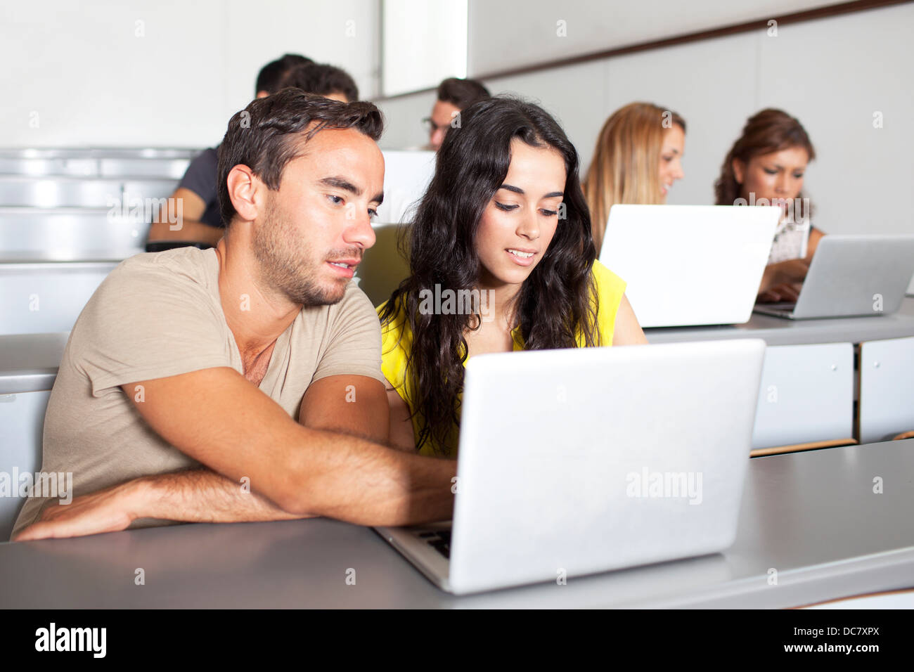 Students studying with laptops in class room Stock Photo - Alamy