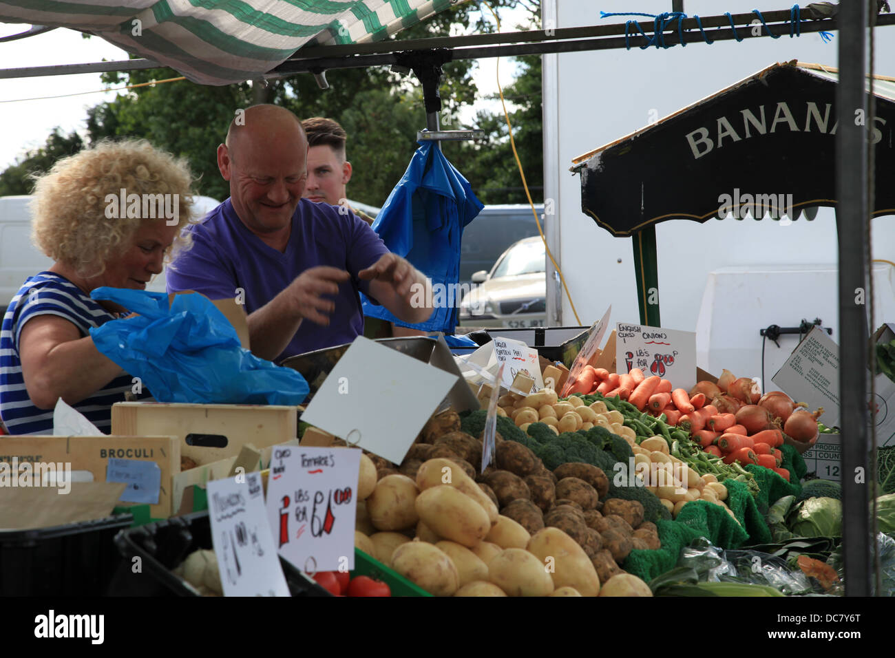 Market stall holder selling fruit and vegetables to customers Stock ...