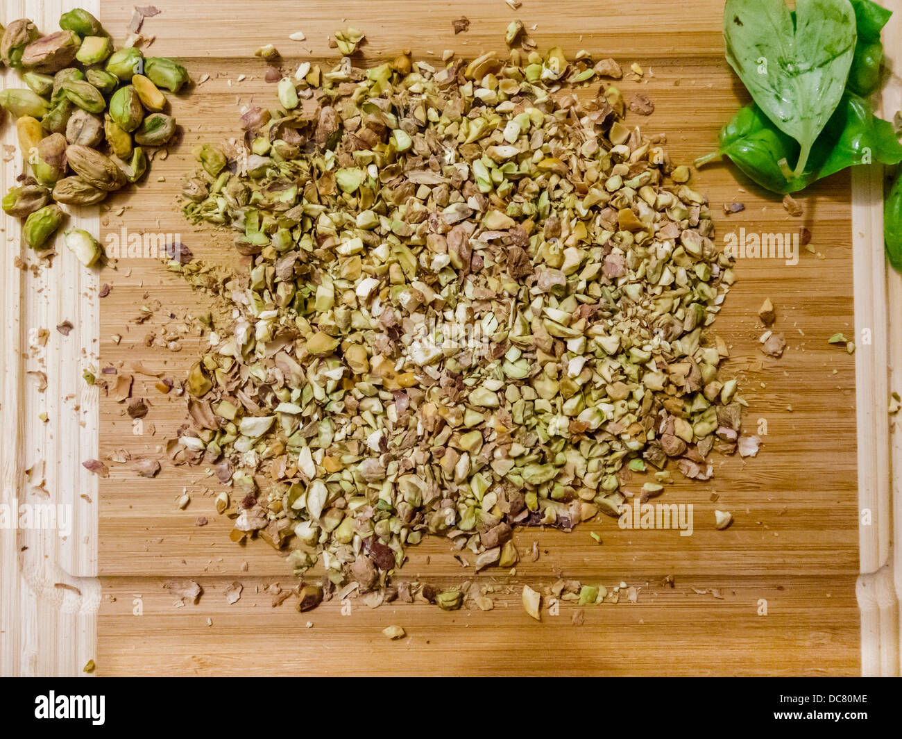 Overhead view of fresh chopped pistachio nuts on a wooden chopping ...