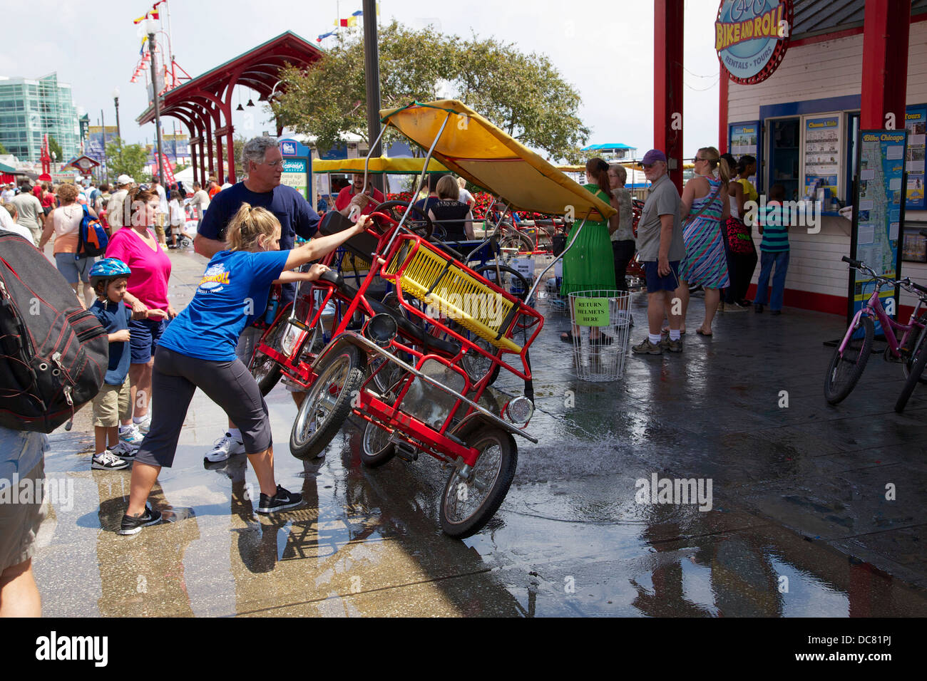 A woman tilts a pedicar to remove water from its canopy after a rain ...