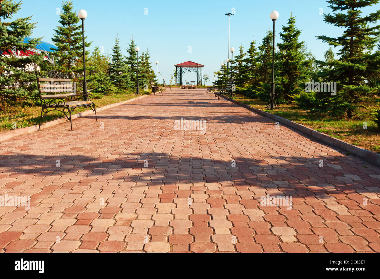 Wide path in nice light park with benches and summerhouse under clean ...