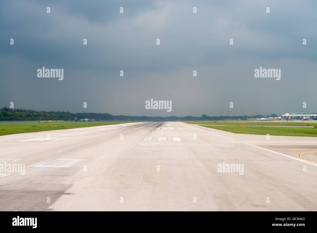 Wide airport runway under dark cloudy storm sky Stock Photo - Alamy