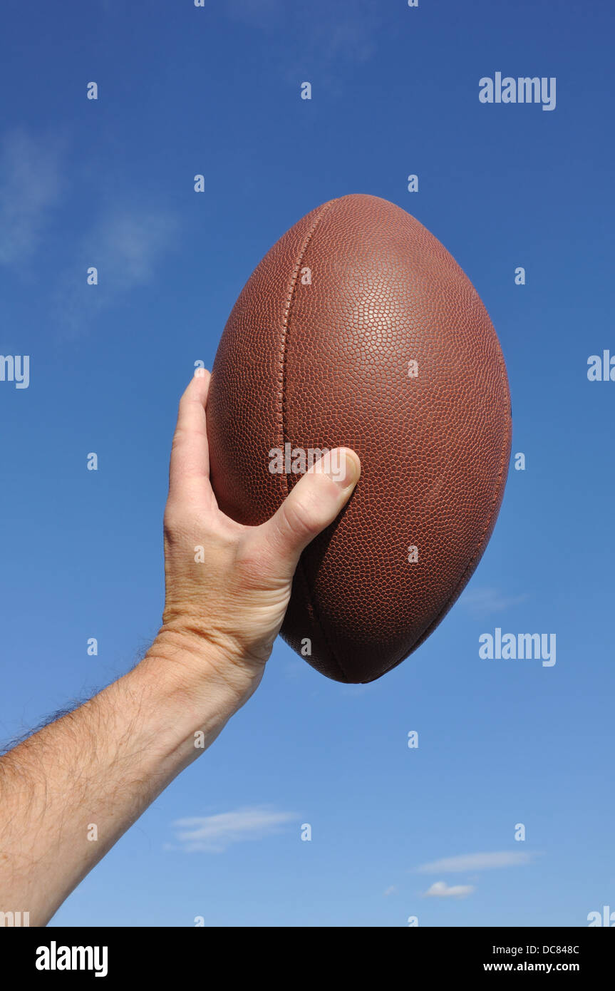 Hand holding an America Football Stock Photo - Alamy