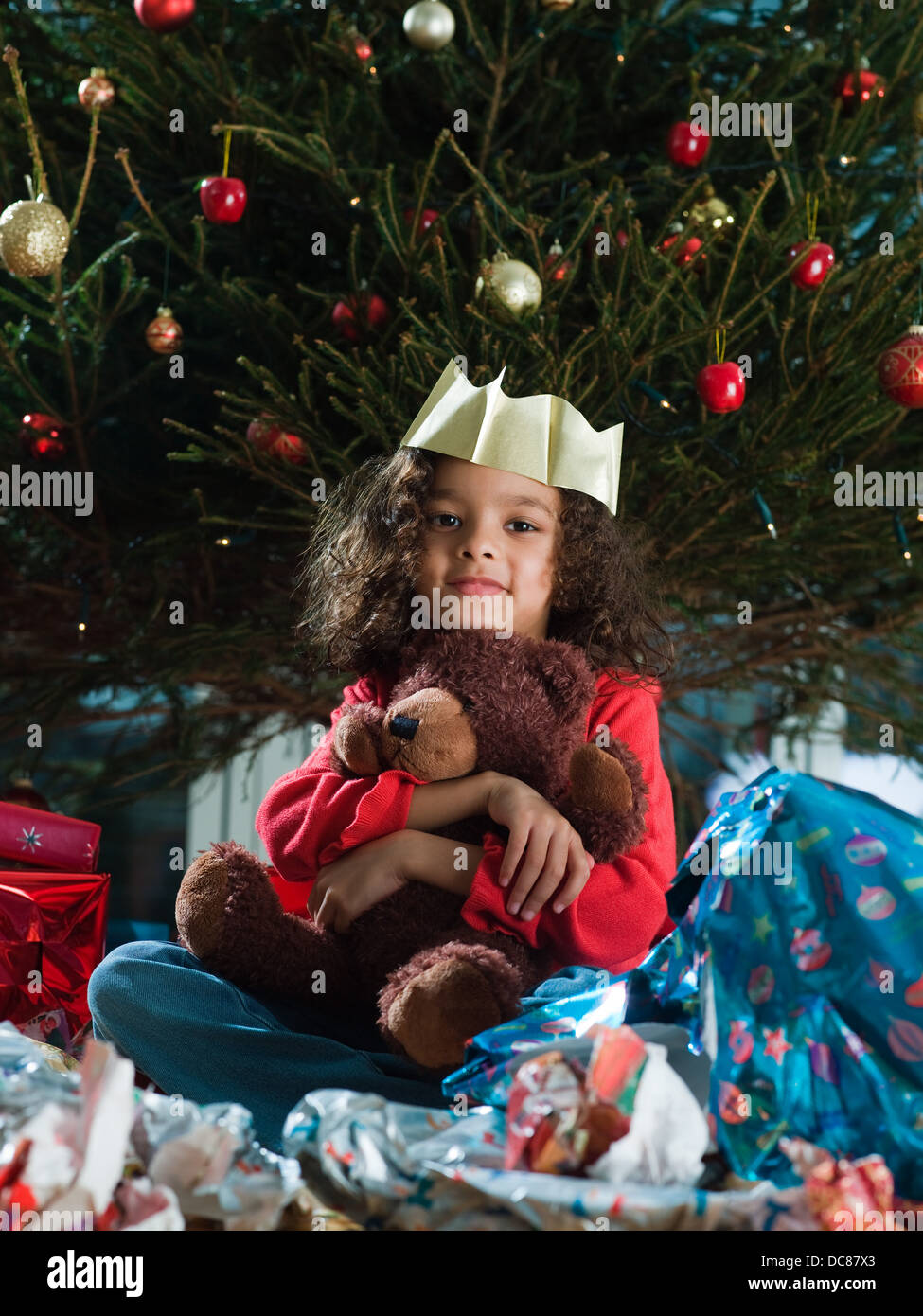 young girl holding teddy under christmas tree Stock Photo - Alamy