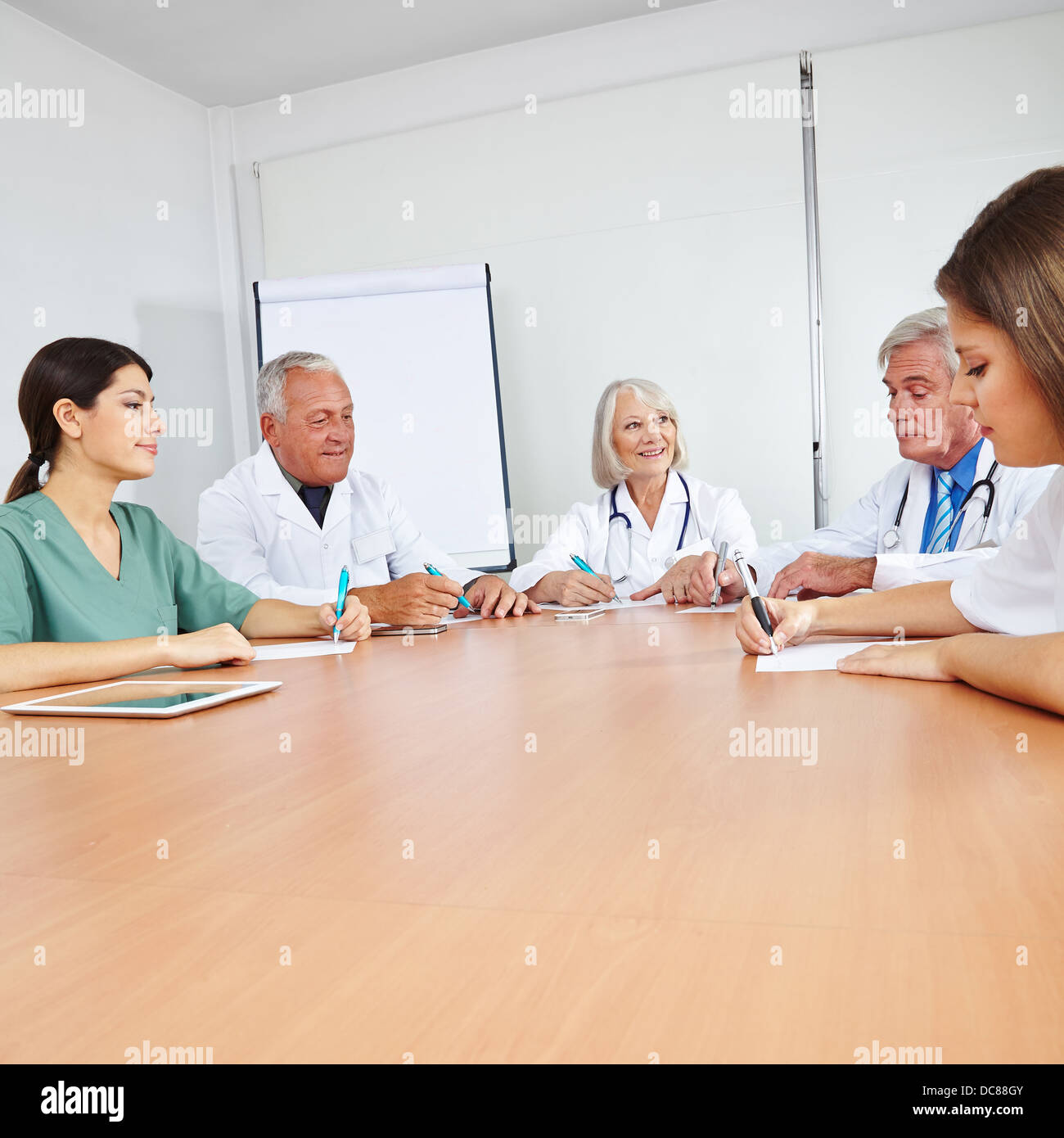 Doctors in a team meeting at a round table Stock Photo - Alamy
