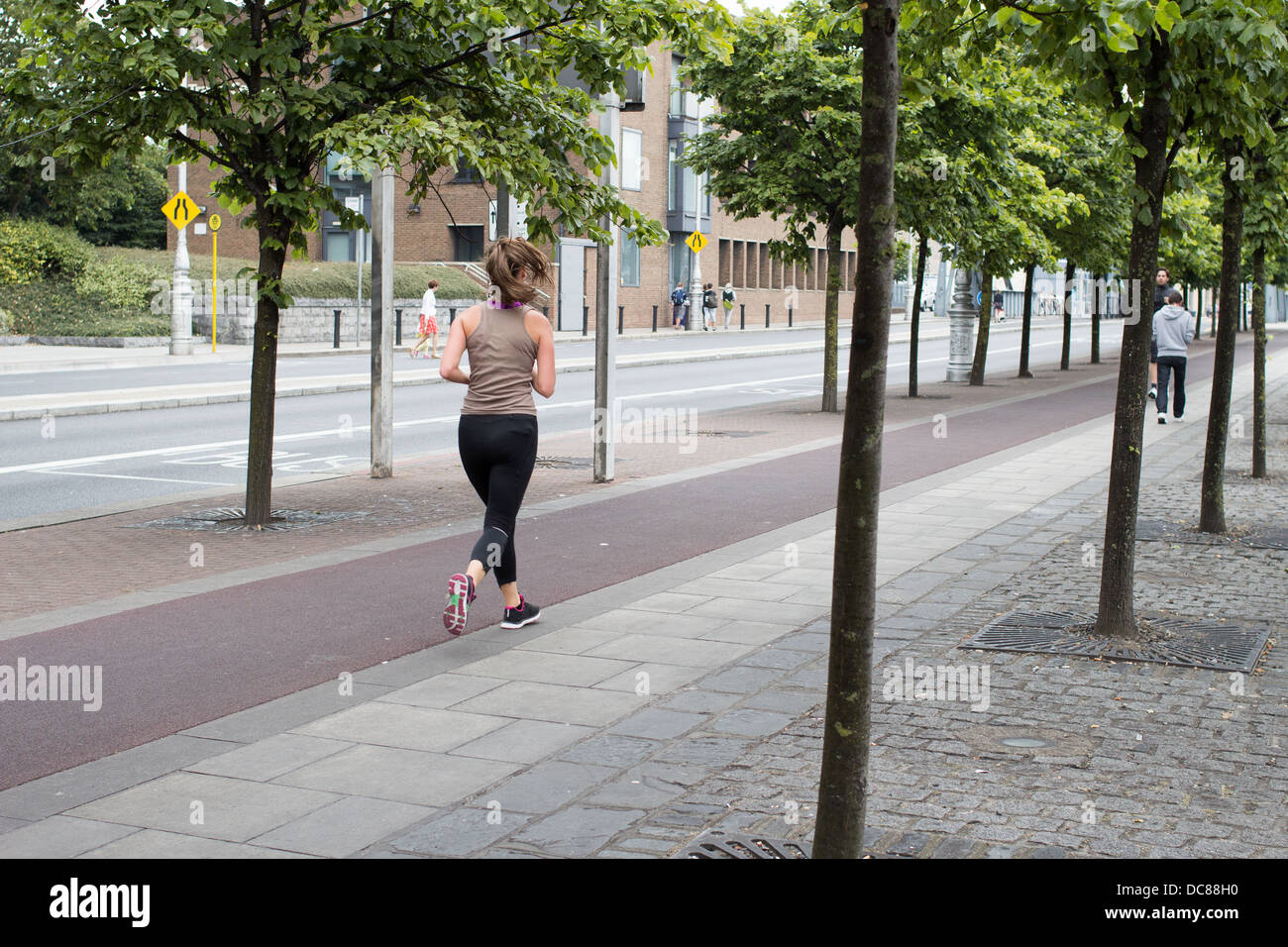 Woman running on a footpath Stock Photo - Alamy