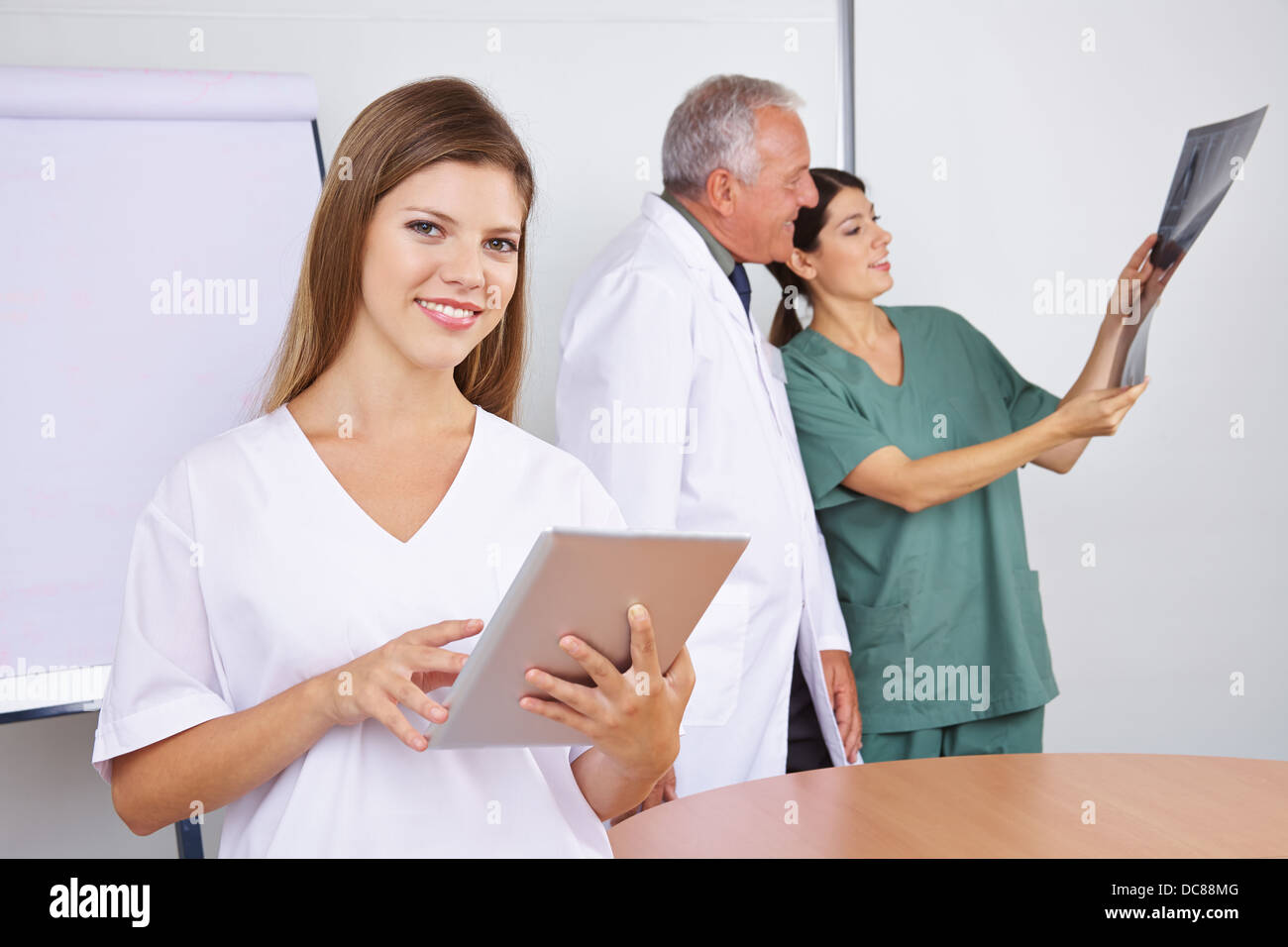 Happy MTA using tablet computer with medial team in background Stock ...