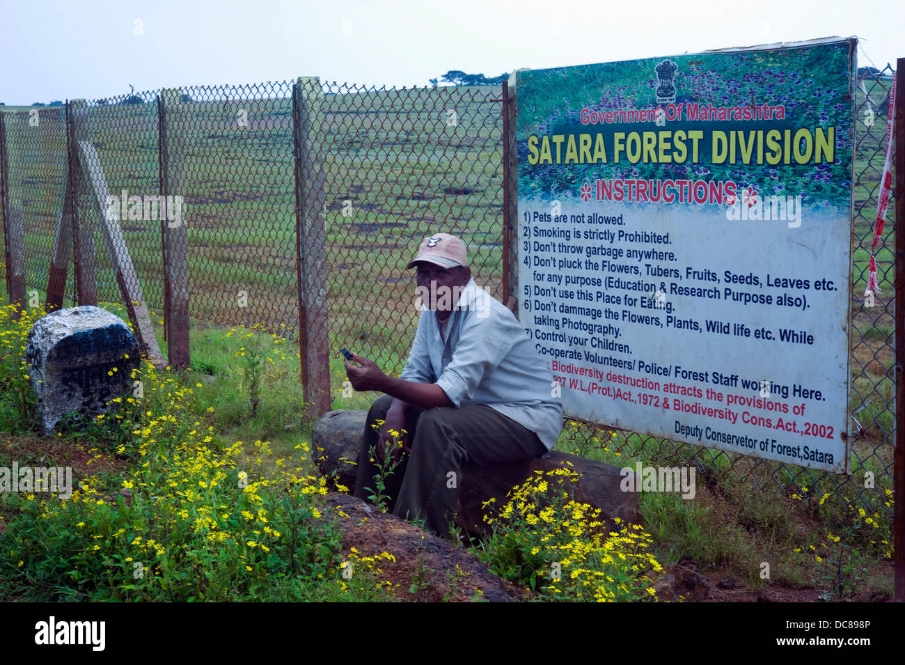 Security Guard sitting in front of Forest Division Placard with ...