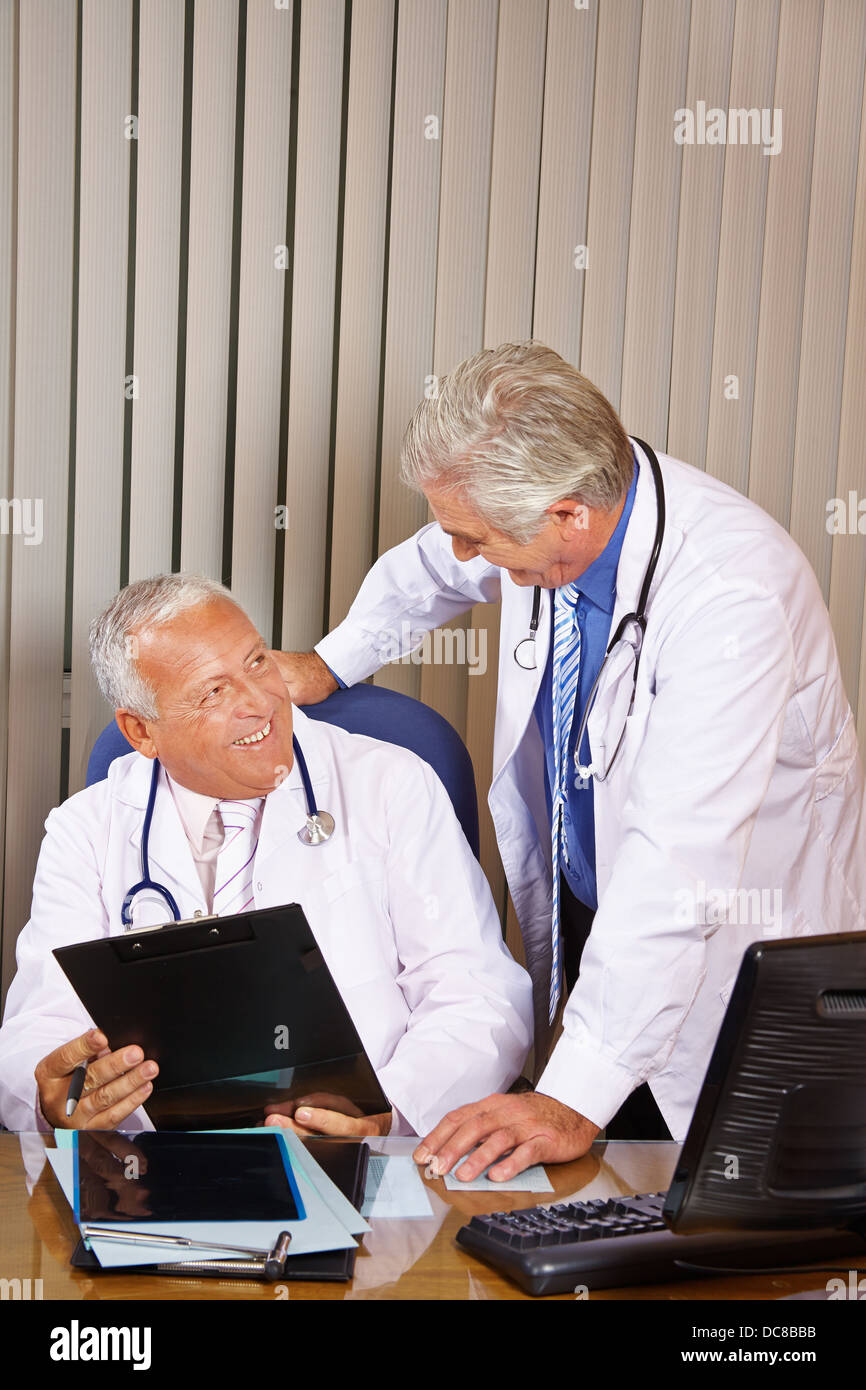 Two senior doctors talking in hospital office to each other Stock Photo ...