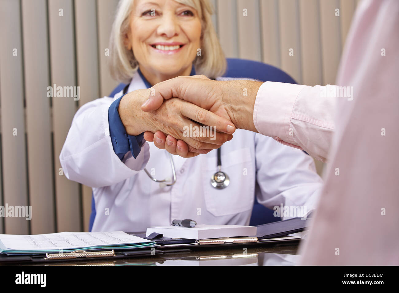 Smiling doctor and patient giving handshake after a consultation Stock ...