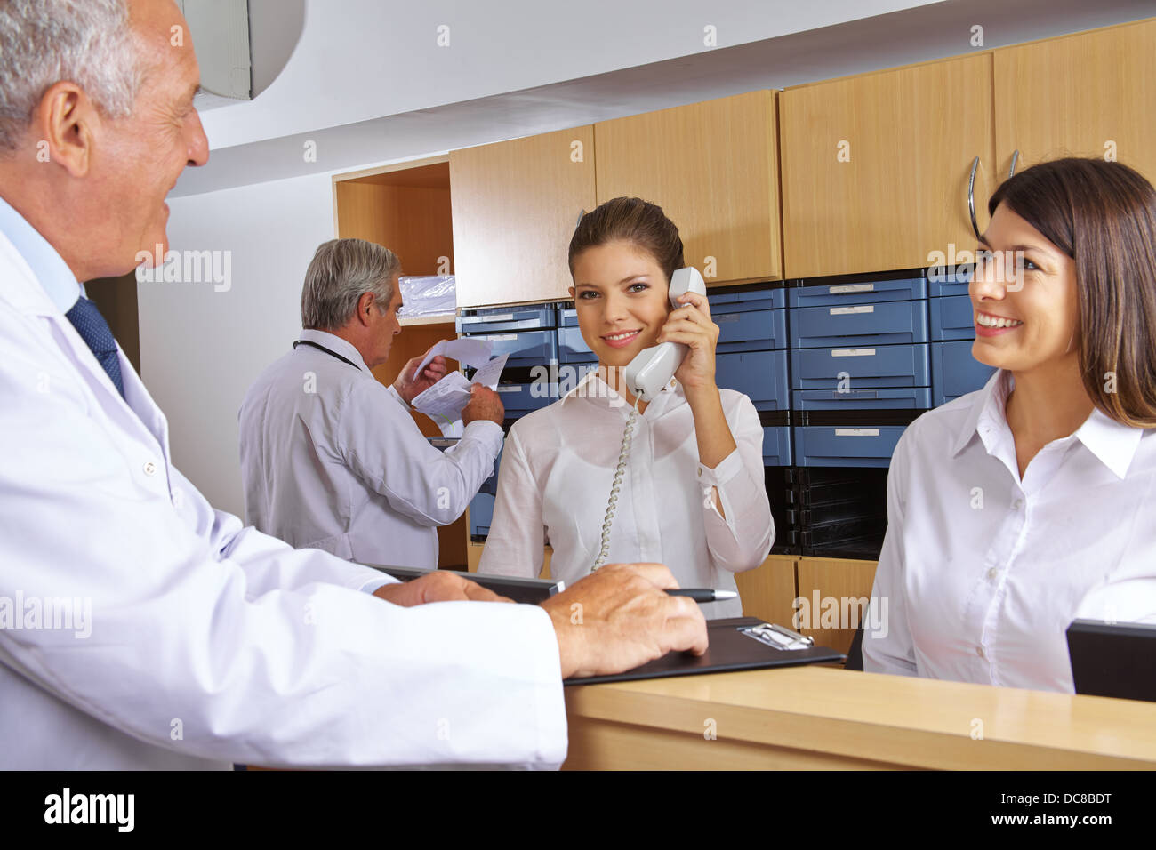 Busy reception in a hospital with doctors and receptionists Stock Photo ...